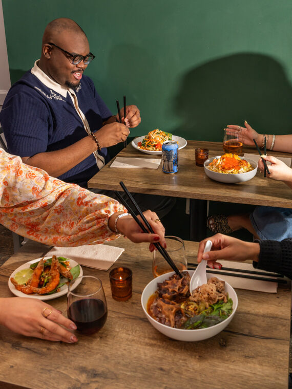 Four friends enjoy a meal of noodles, shrimp, salads and more at Mawn.